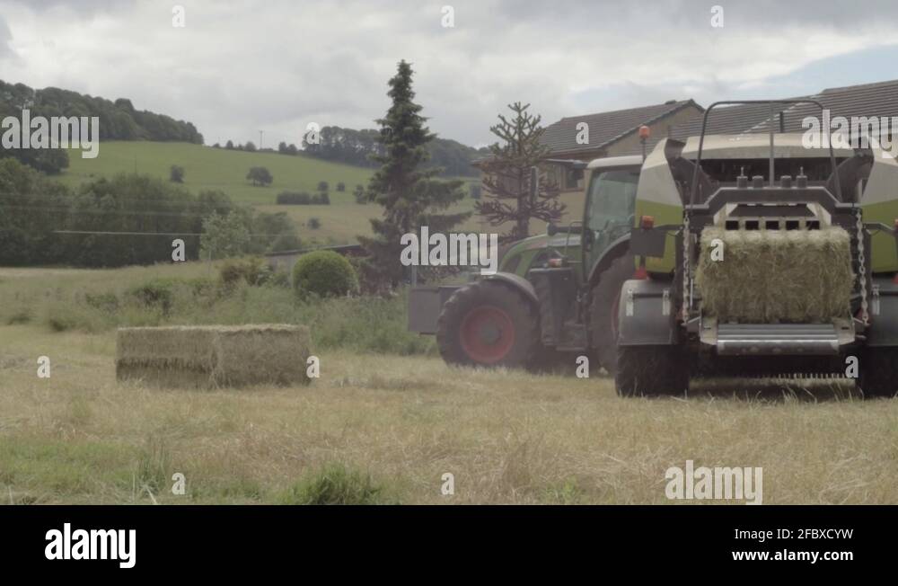 Tractor turning in hay field pulling a baler Stock Video Footage - Alamy