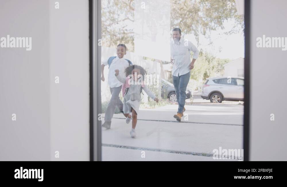 Father Bringing Excited Children Back Home From School Opens Front Door ...