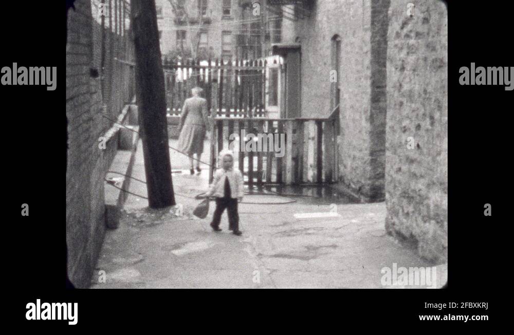 1920s: UNITED STATES: lady and girl in back alley behind house. Shoe ...