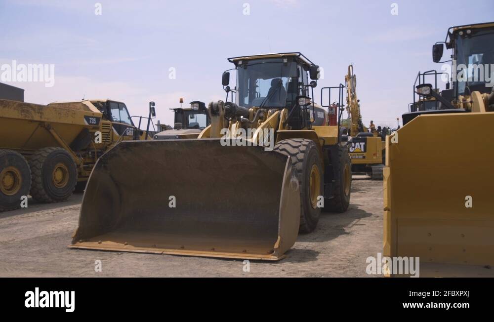 Rows of bulldozers lined up ready to be used at a construction site ...