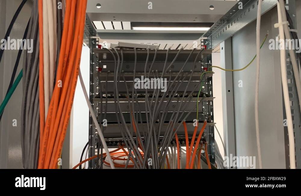 Many cables and switches in a server cabinet in a server room in a ...