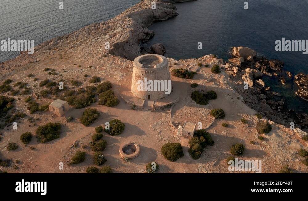 Pirate tower in Ibiza. Aerial view panning around lookout tower showing ...