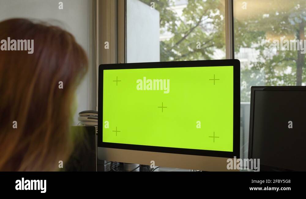 Woman working on personal computer with Mock-up Green Screen in her ...
