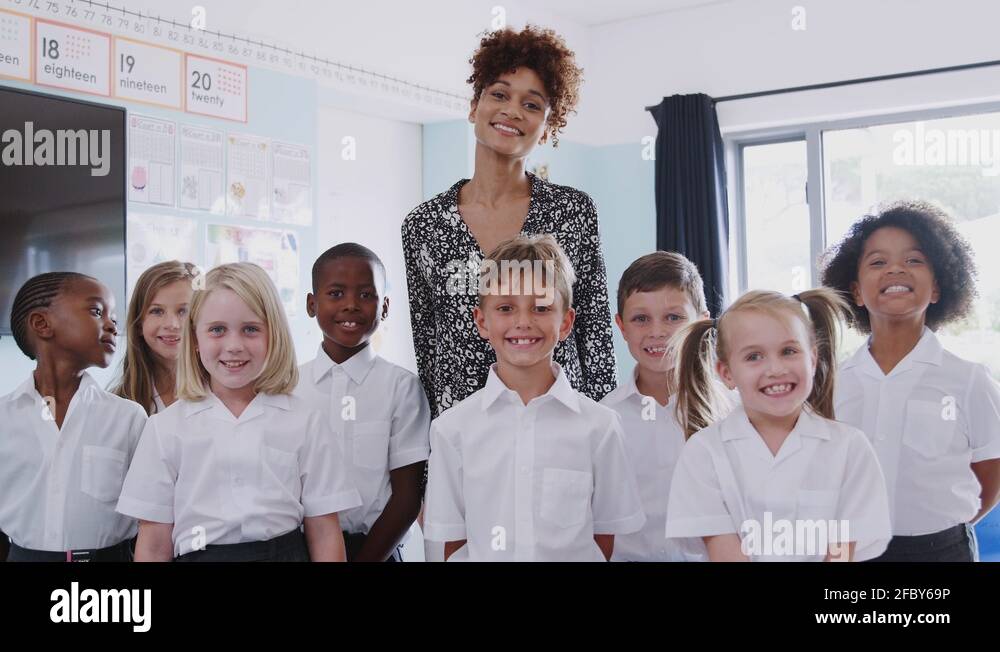 Portrait Of Elementary School Pupils Wearing Uniform In Classroom With ...