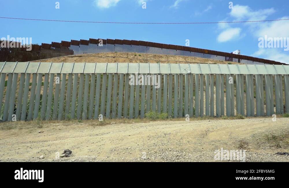 Double border fence dividing USA and Mexico. Between the fence a border ...