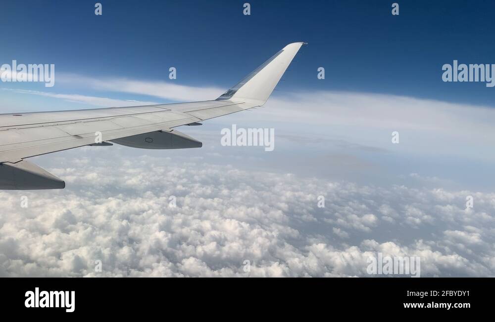 Flying high above the clouds. This shows an aircraft wing flying ...