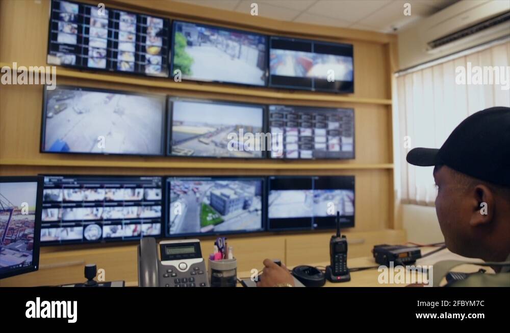 A port control room view, a uniformed officer monitoring the security ...