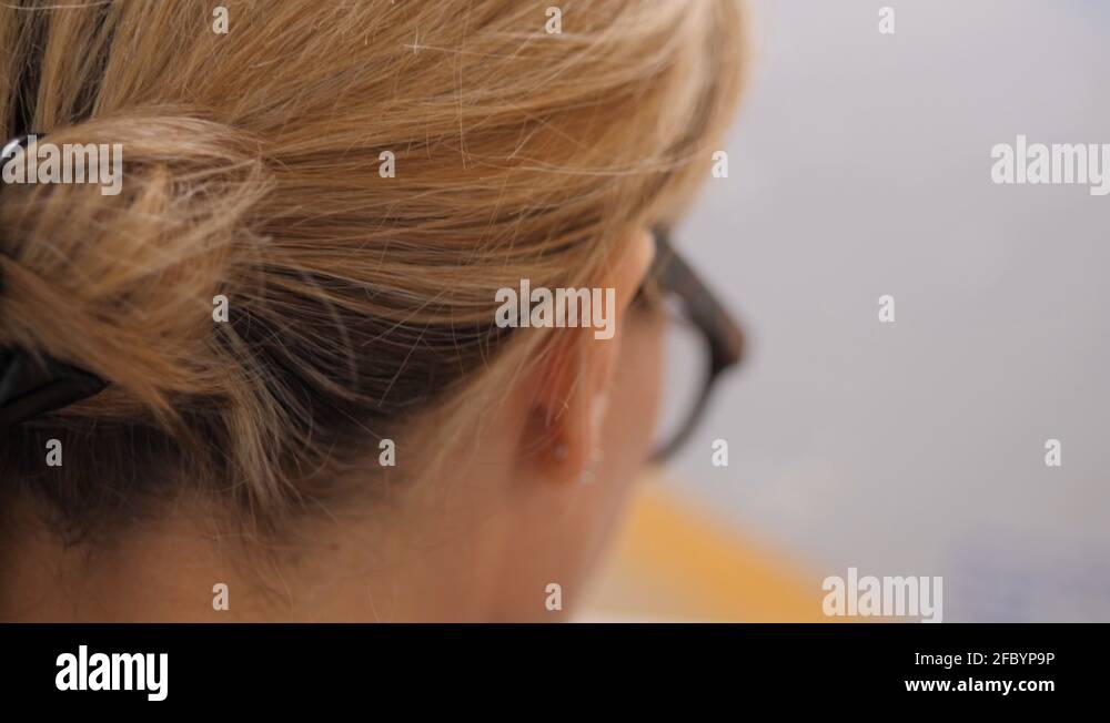 Back view and over the shoulder of artist woman drawing with pencil ...