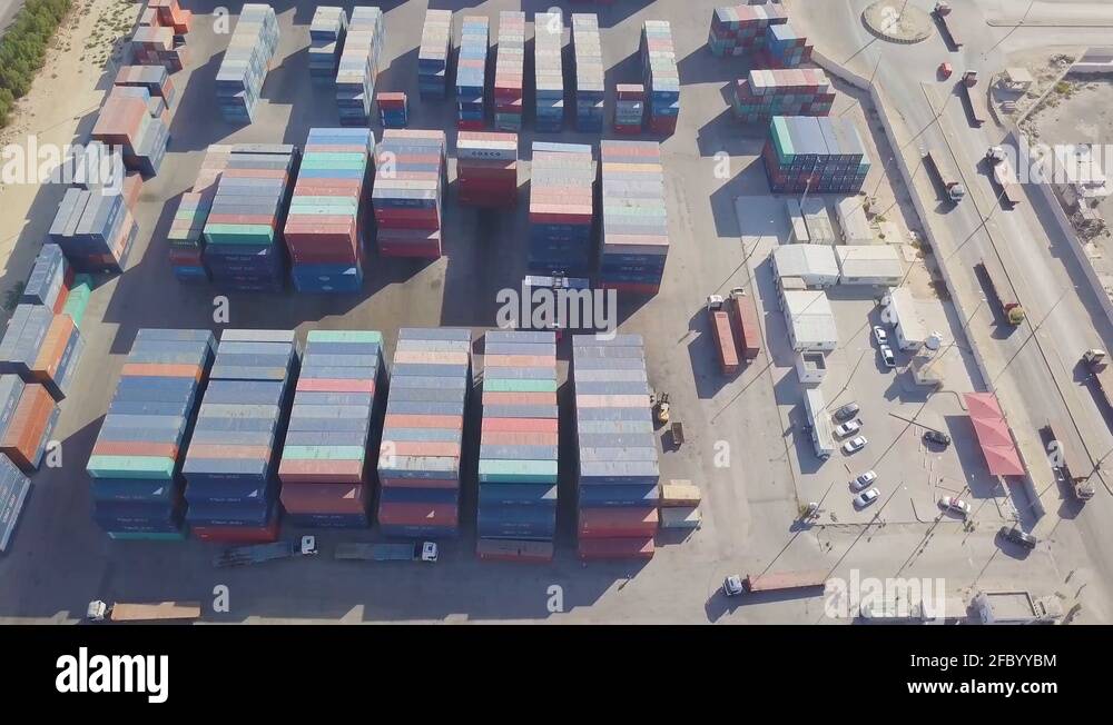 A fleet of trucks enter the massive container yard with colorful Stock ...