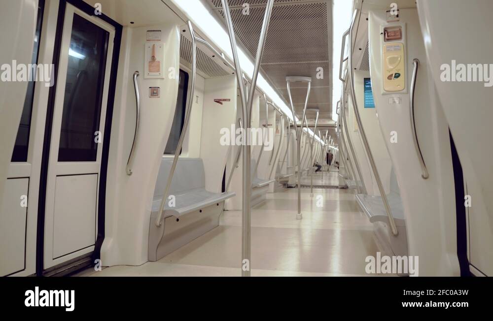 An interior view of modern white long subway train driving in high ...