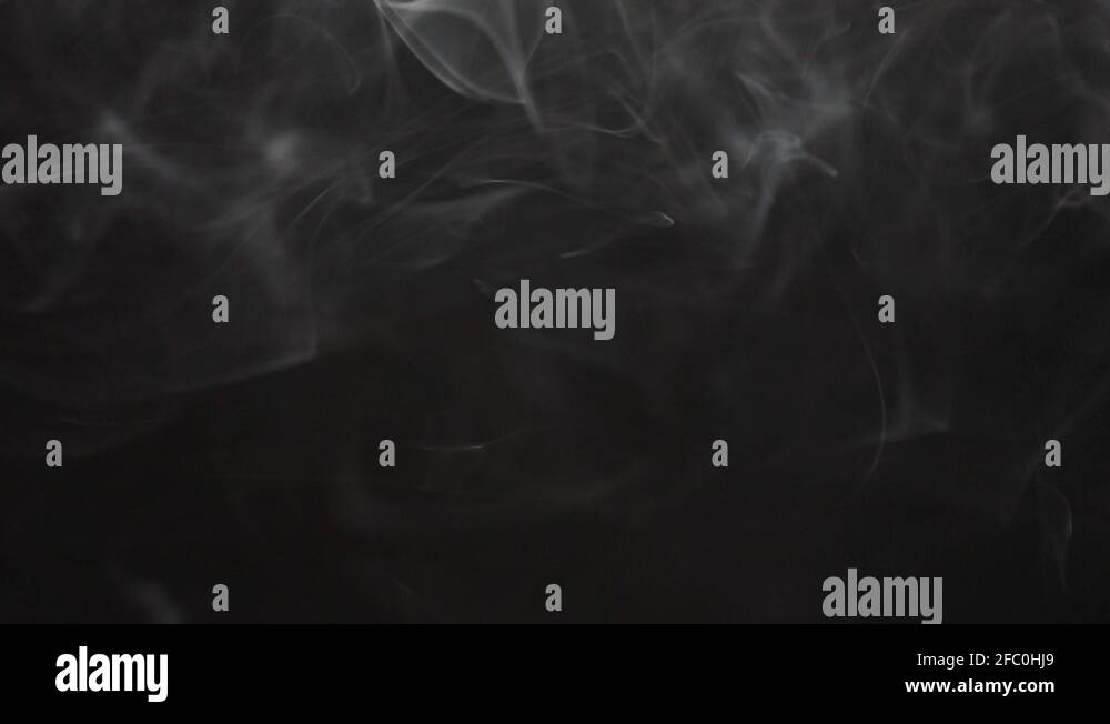 Thin smoke threads rising and spreading in the air. Smoke cloudsing and ...