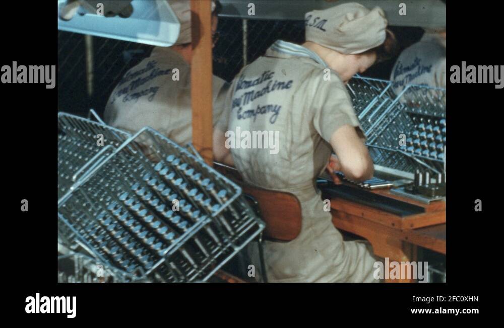 1950s: Women in rows at work stations, take bullet shell casing from ...