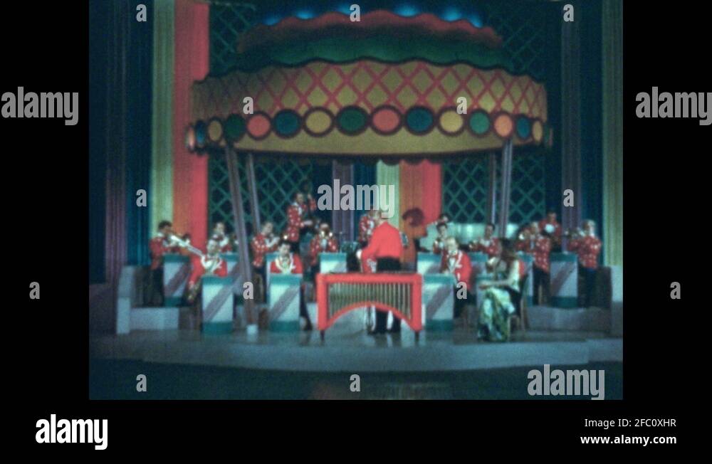 1940s: A big band sits on a colorful stage, wearing red and white ...