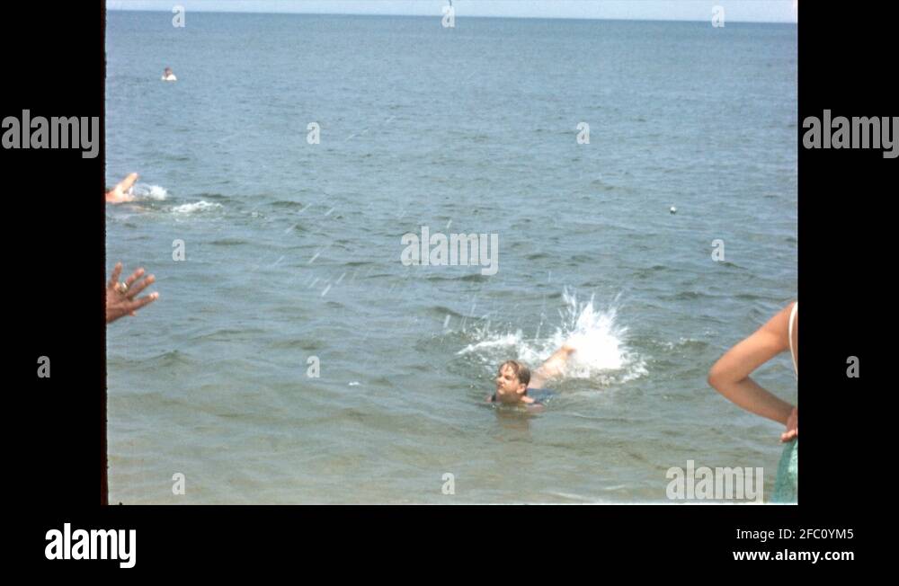 1950s: Families wade and swim in ocean at beach Stock Video Footage - Alamy