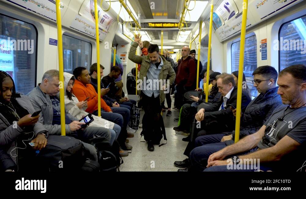 Diverse Commuters Looking At Phones inside Subway Tube Train in London ...
