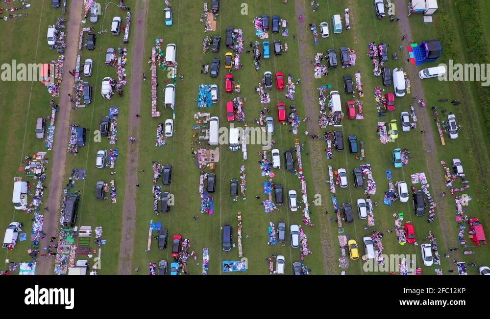 Birds-eye aerial view of a busy car boot sale with lifting reveal to ...