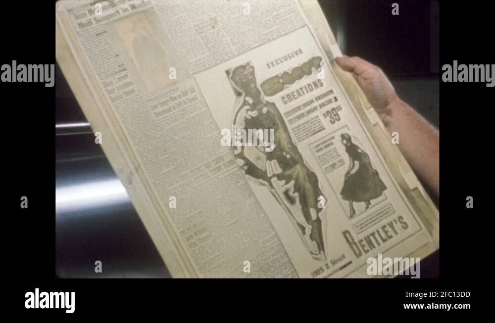 1950s: UNITED STATES: hand holds newspaper. Newspaper article and ...