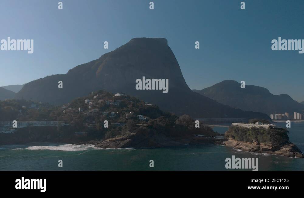 Sideways aerial pan showing the Joatinga beach on a hazy backlit day ...