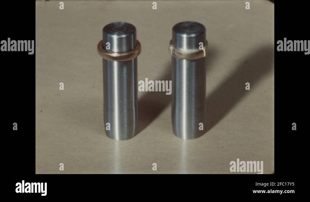 1950s: Two metal bullet shell casings sit side by side on table, each ...