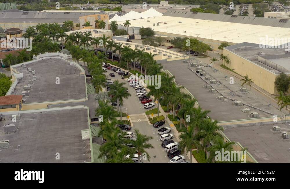 Aerial flyover of Sawgrass Mills Mall. Outlet shops with palm trees ...