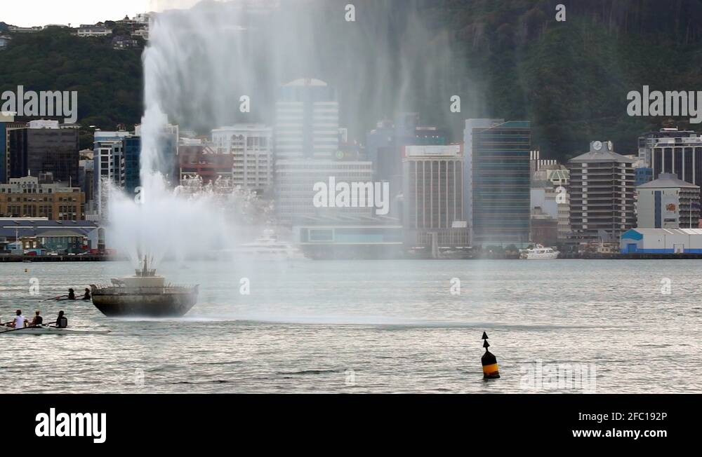 Water spouting from The Carter Fountain with people rowing past in ...
