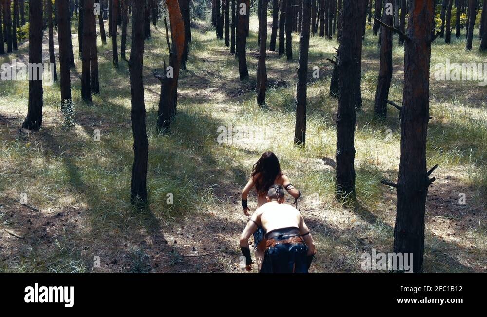 Muscular man is running after a barbarian woman in the forest, 4k Stock ...