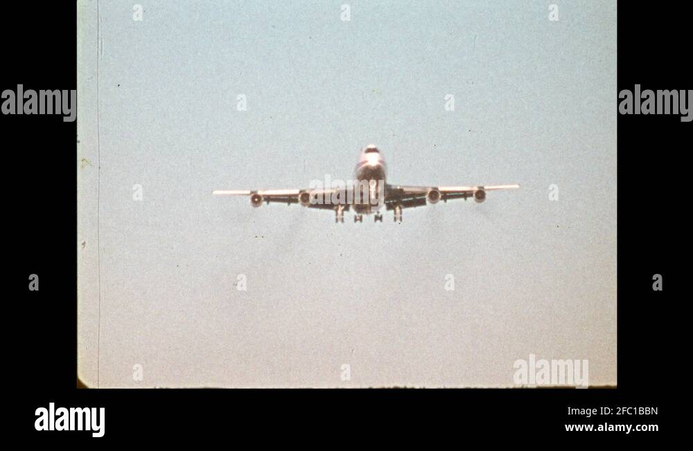 1970s: UNITED STATES: plane in sky. Plane coming in to land. Reflection ...