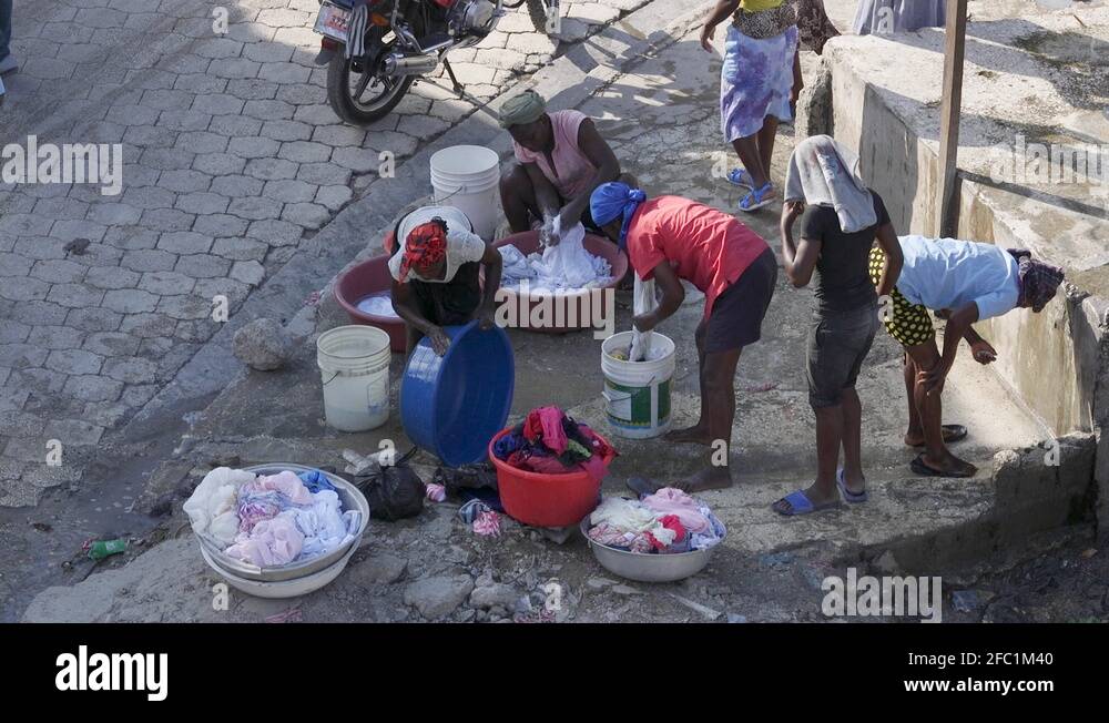 Women washing clothes on the street in a Petion-Ville neighborhood ...