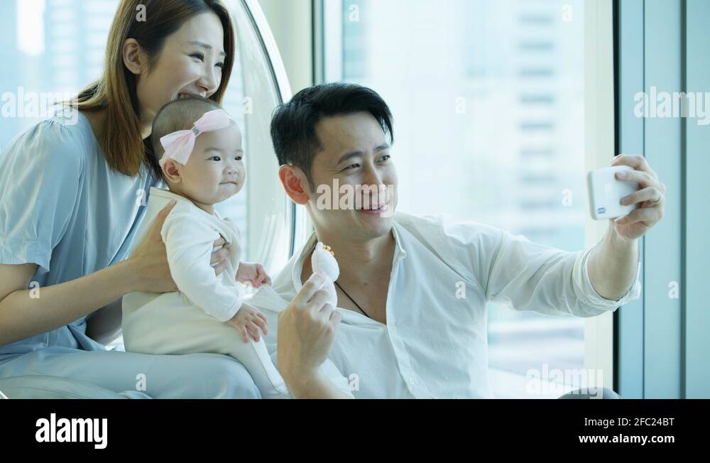 Chinese Asian parents baby enjoying smartphone wifi technology Stock ...
