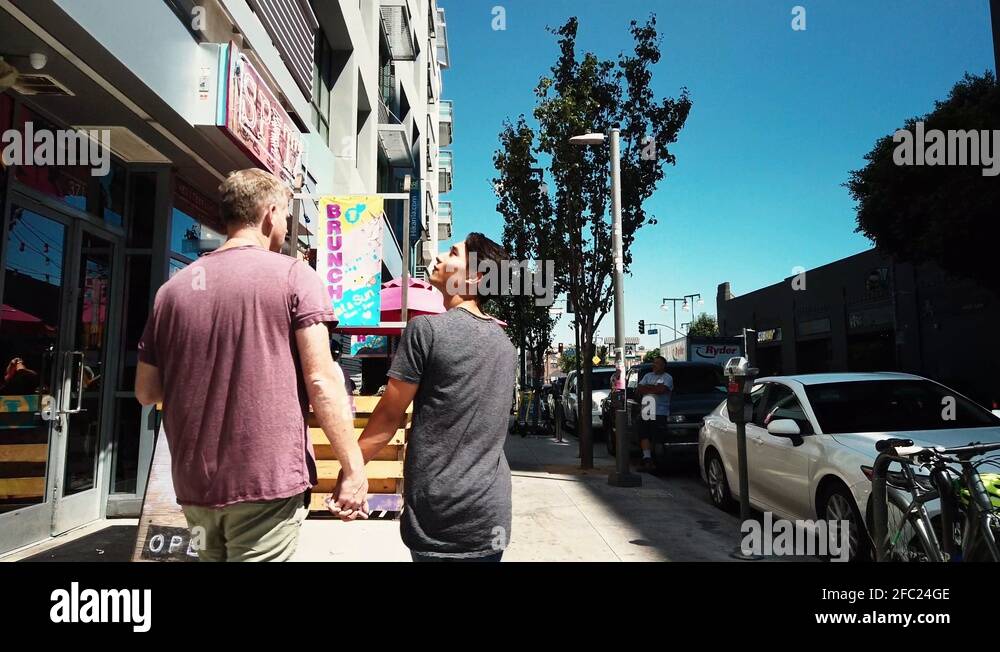Gay Couple Holding Hands Proudly Walking On Streets Of Los Angeles