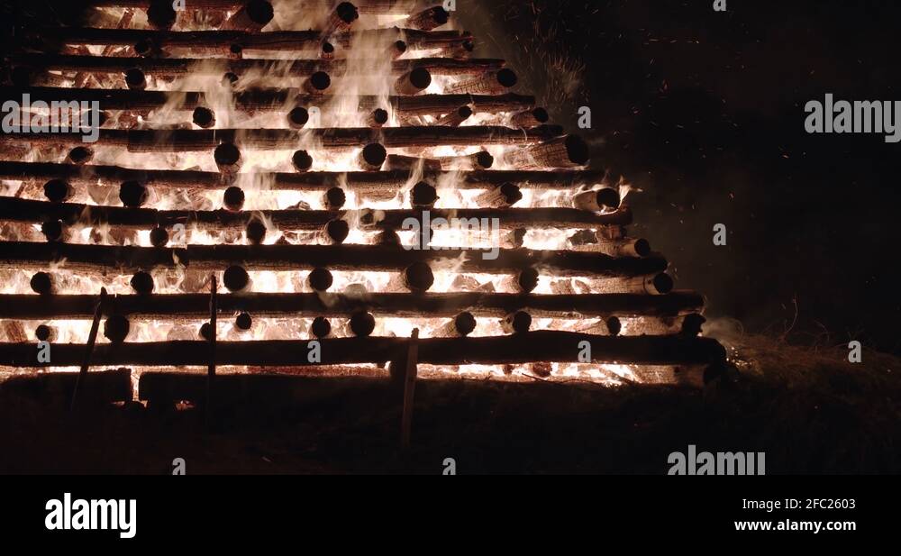 Fire flames and sparks in sacrificial fire. out of focus people slow ...