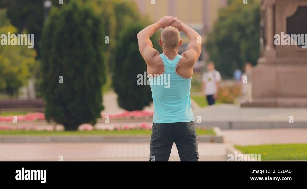 Exercises for hands in the fresh air. Athlete stretches the muscles of ...