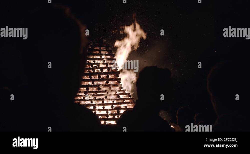 Fire flames and sparks in sacrificial fire. out of focus people slow ...