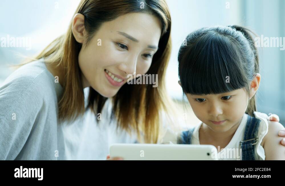 Chinese Asian mother helping young daughter technology device Stock ... Chinese Asian mother helping young daughter technology device Stock ...