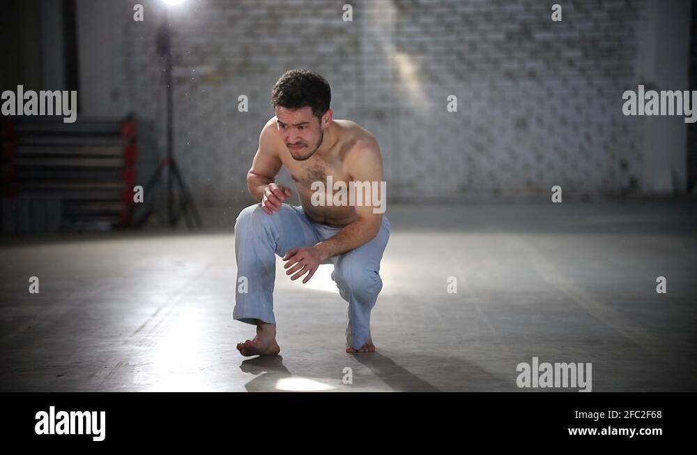 Man jumping on his hands and lifting feet up, then he turns around ...