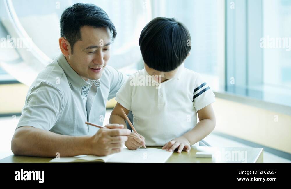 Chinese Asian single dad enjoying drawing with son Stock Video Footage ...