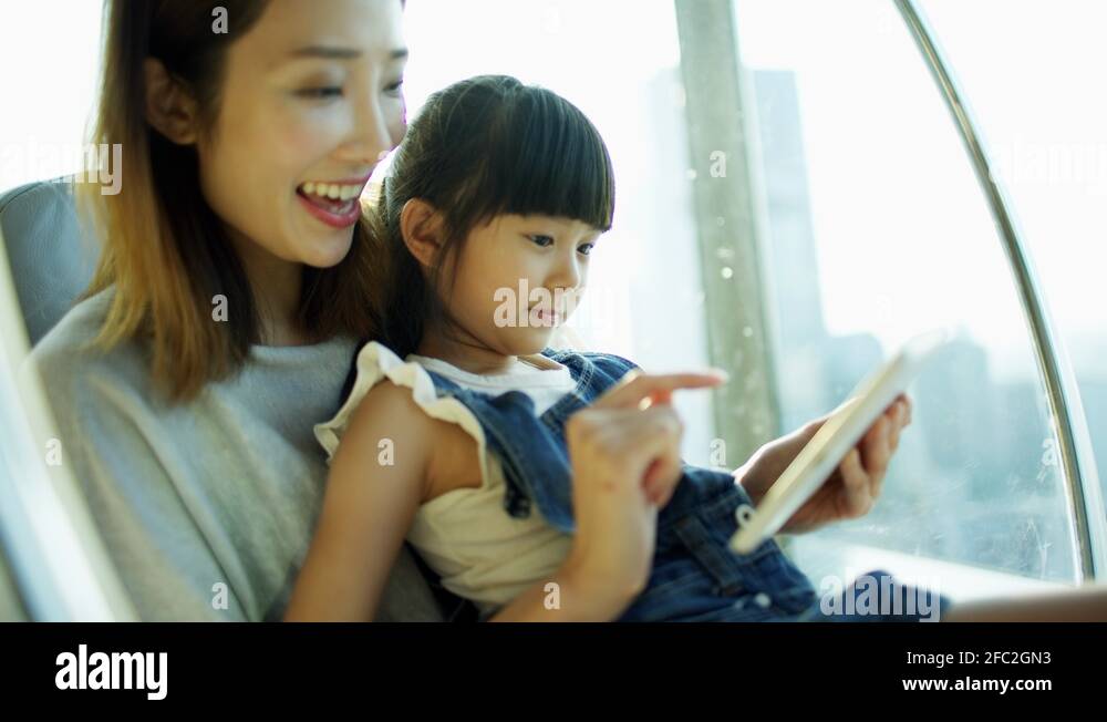 Chinese Asian mother helping young daughter technology device Stock ... Chinese Asian mother helping young daughter technology device Stock ...