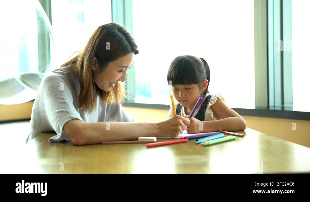 Chinese Asian single mother enjoying daughter colouring activities ...