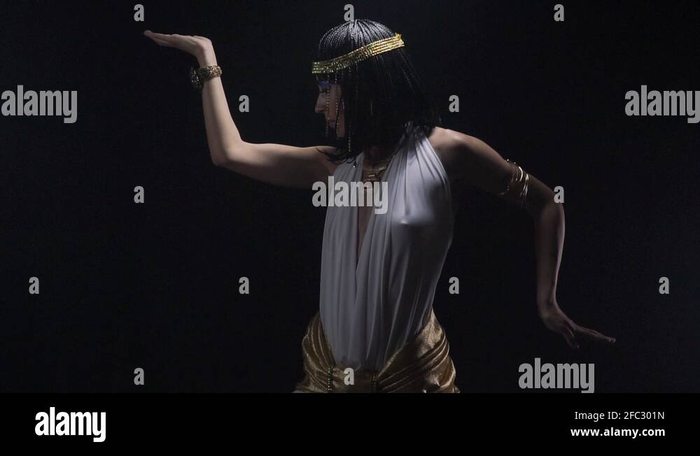 Cleopatra wearing white dress is doing ancient egyptian poses, slow ...
