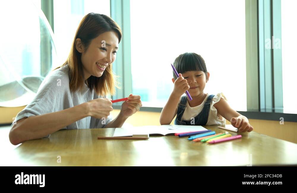 Chinese Asian single mother enjoying daughter coloring work Stock Video ...
