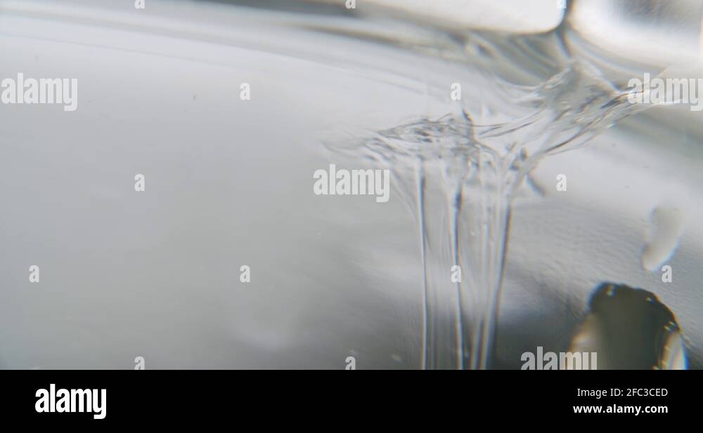 close up detail shot of a transparent viscous liquid floating in water ...