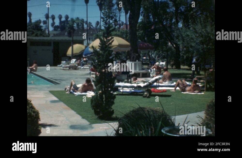 1940s: People lounge around next to pool, swim in pool. Blimp flies in ...