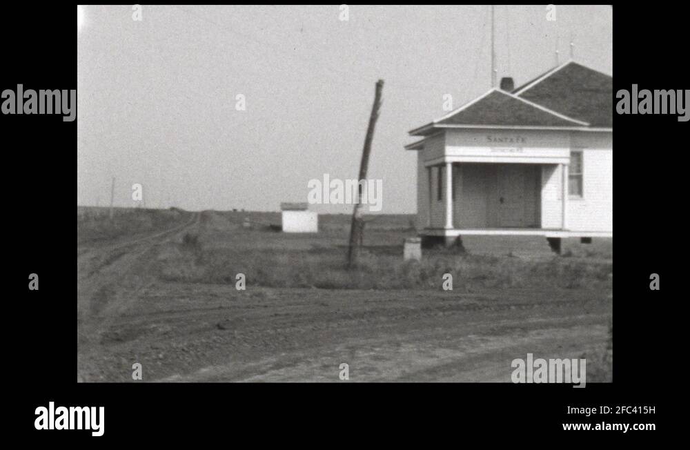 1920s: UNITED STATES: building on corner of road. Fence by field. Trees ...
