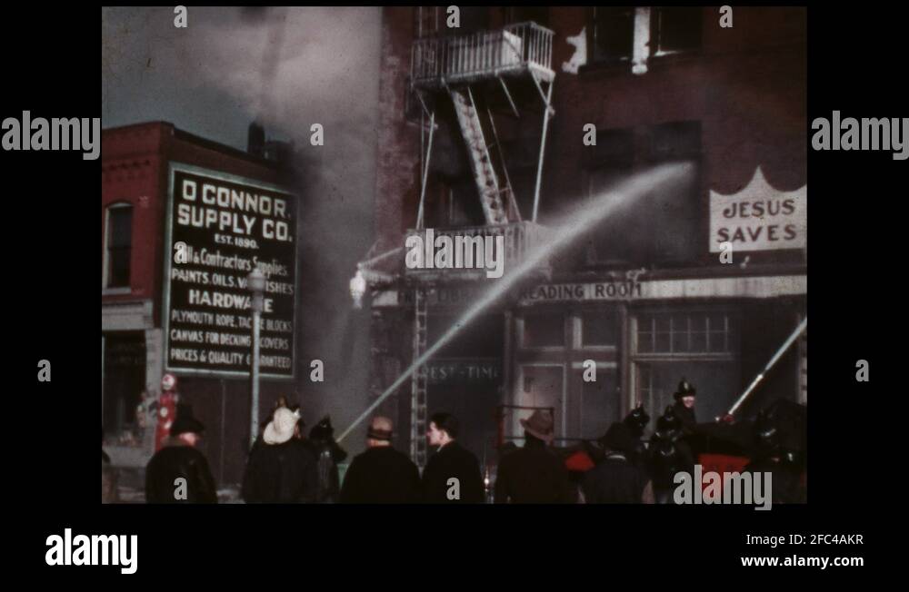1930s: UNITED STATES: fire men fight fire in building with hoses and ...