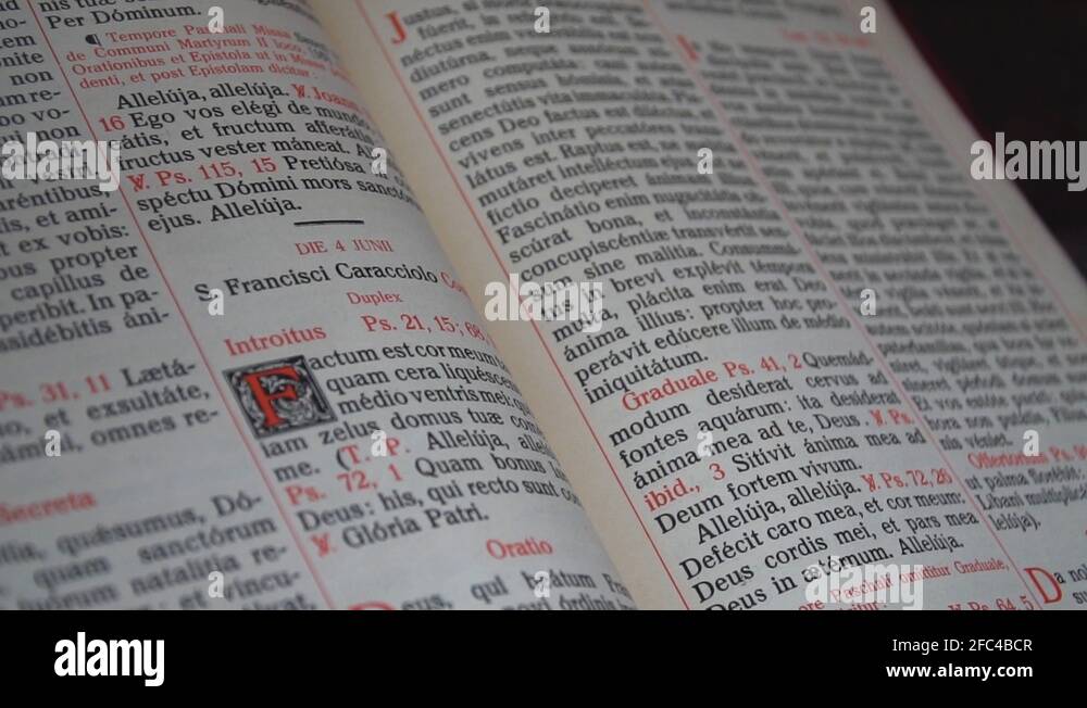 Tight shot and panning of a page in a latin Bible inside of a church ...