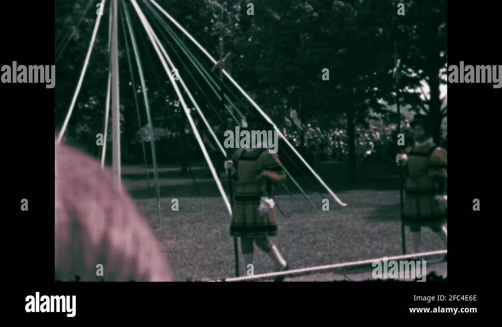 1940s: People in costume march slowly. People carry queen on their ...