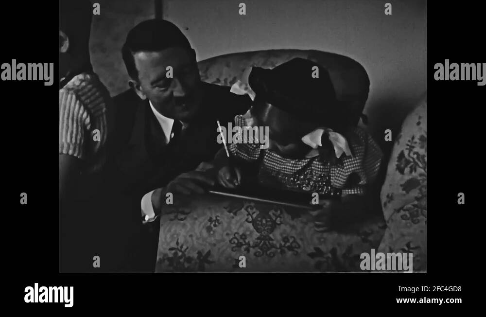 WW2 - Adolf Hitler sit with two childs on a sofa - girl paint something ...