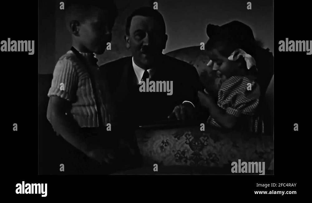 WW2 - Adolf Hitler sit with two childs on a sofa - girl paint something ...
