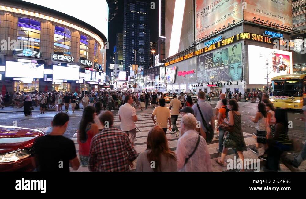 Crowd of people walking in Times Square New York City at night time ...