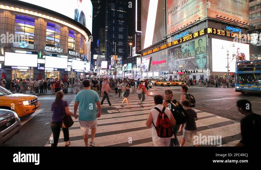 Crowd of people walking in Times Square New York City at night ...